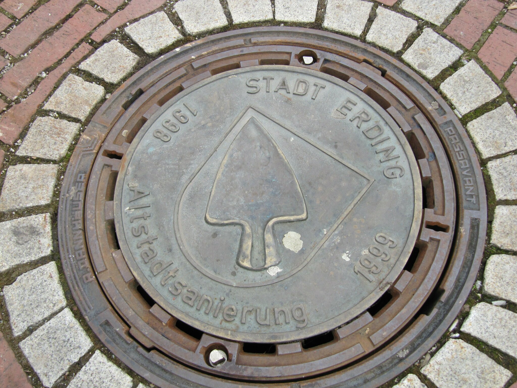 Kanaldeckel in Erding, 100 Jahre Stadt Erding 1899 bis 1999, gesehen in der Fußgängerzone.